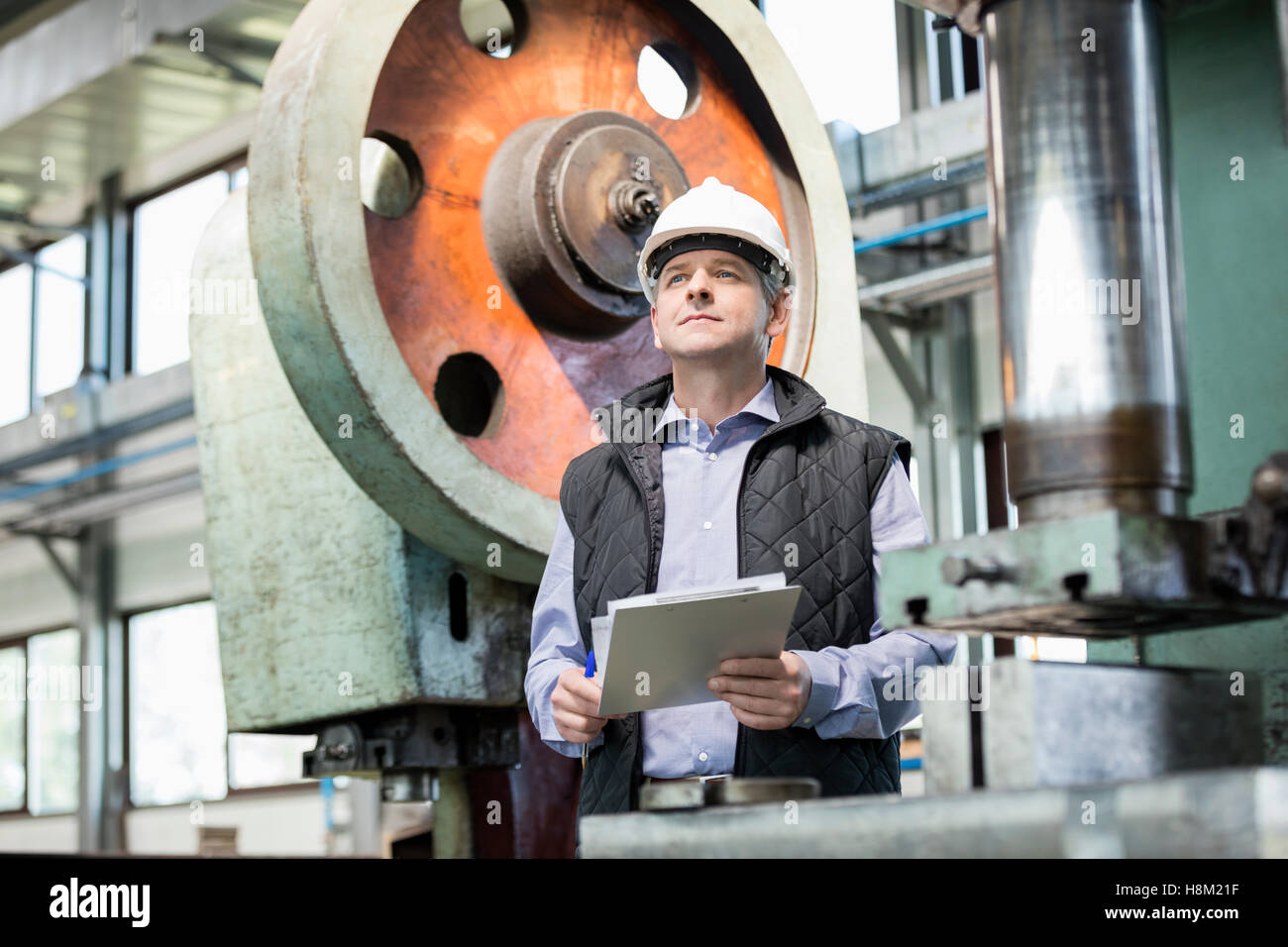 Male supervisor holding clipboard in metal industry Stock Photo - Alamy