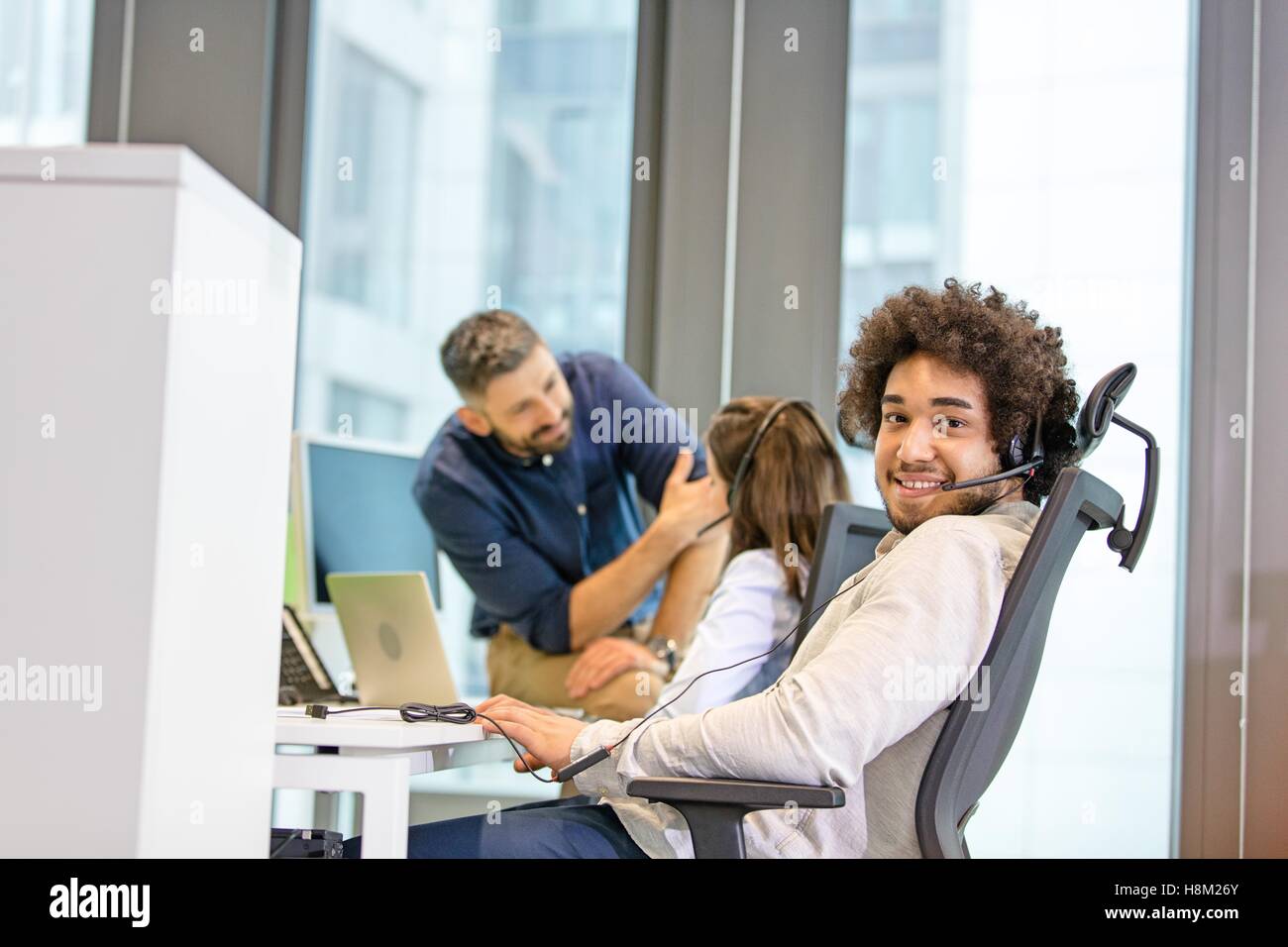Portrait of male customer service representative with colleagues in ...