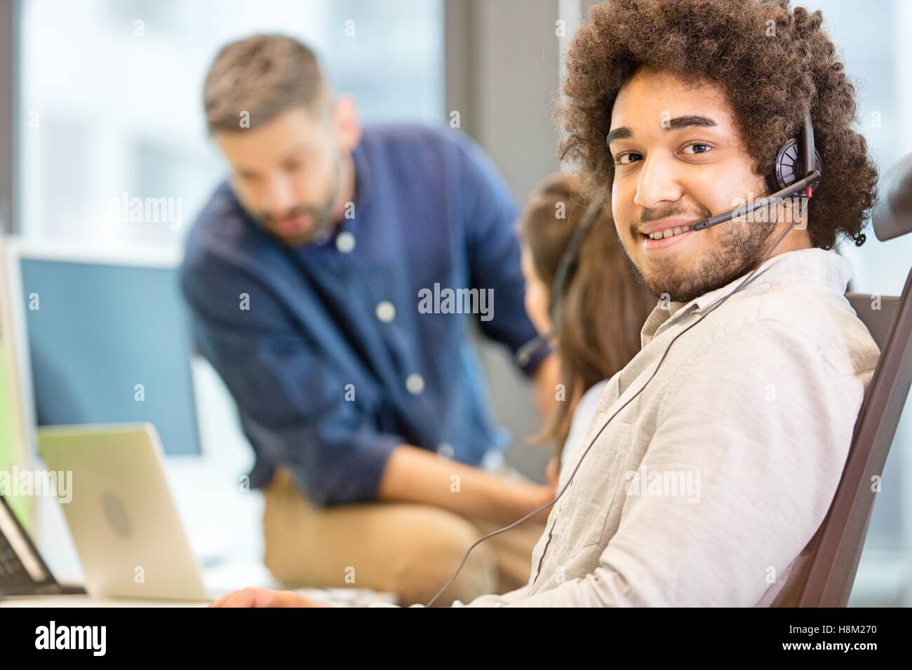 Portrait of confident customer service representative with colleagues ...