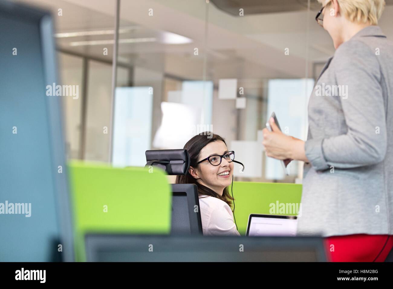 Female customer service representative talking with manager in office ...