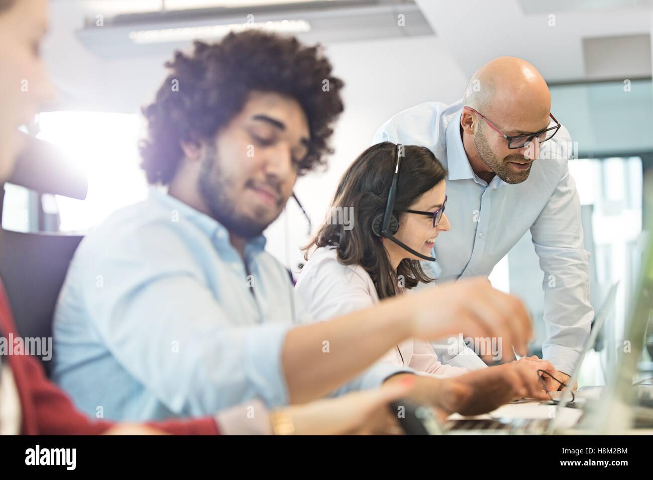 Manager and female operator having discussion with colleagues in ...