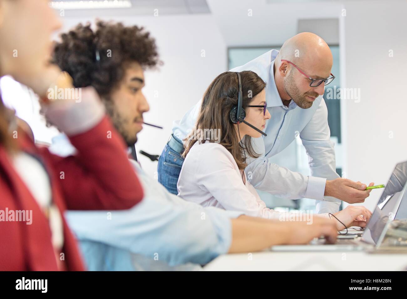 Male manager and female operator having discussion with colleagues in ...