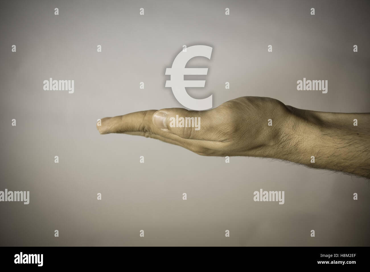 Human hand on vintage background with euro symbol Stock Photo - Alamy