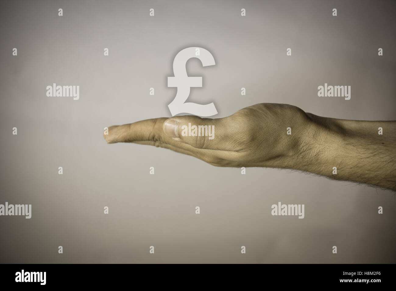 Human hand on vintage background with pound symbol Stock Photo - Alamy