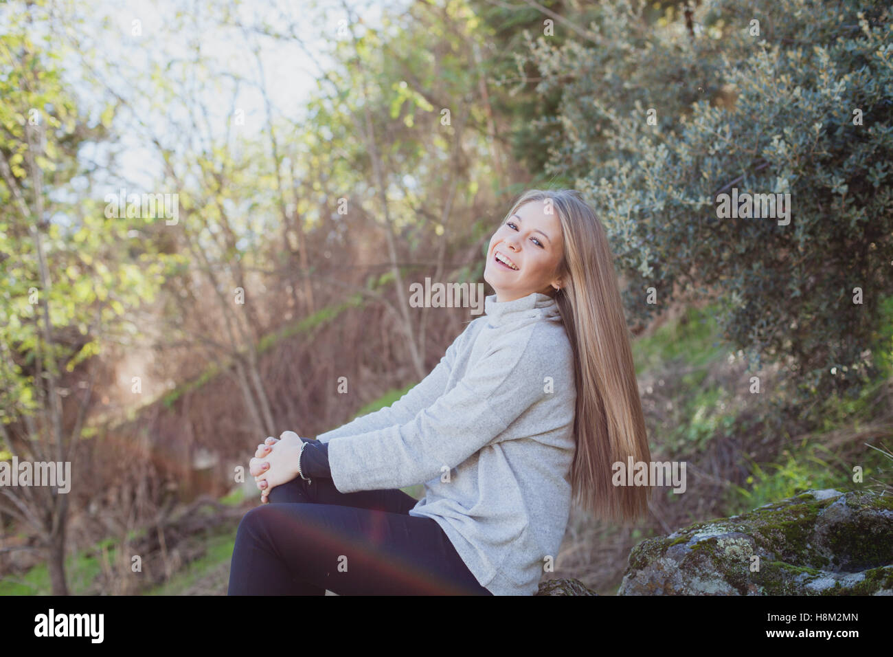 Young woman sitting on a big stone in a relaxed day Stock Photo - Alamy