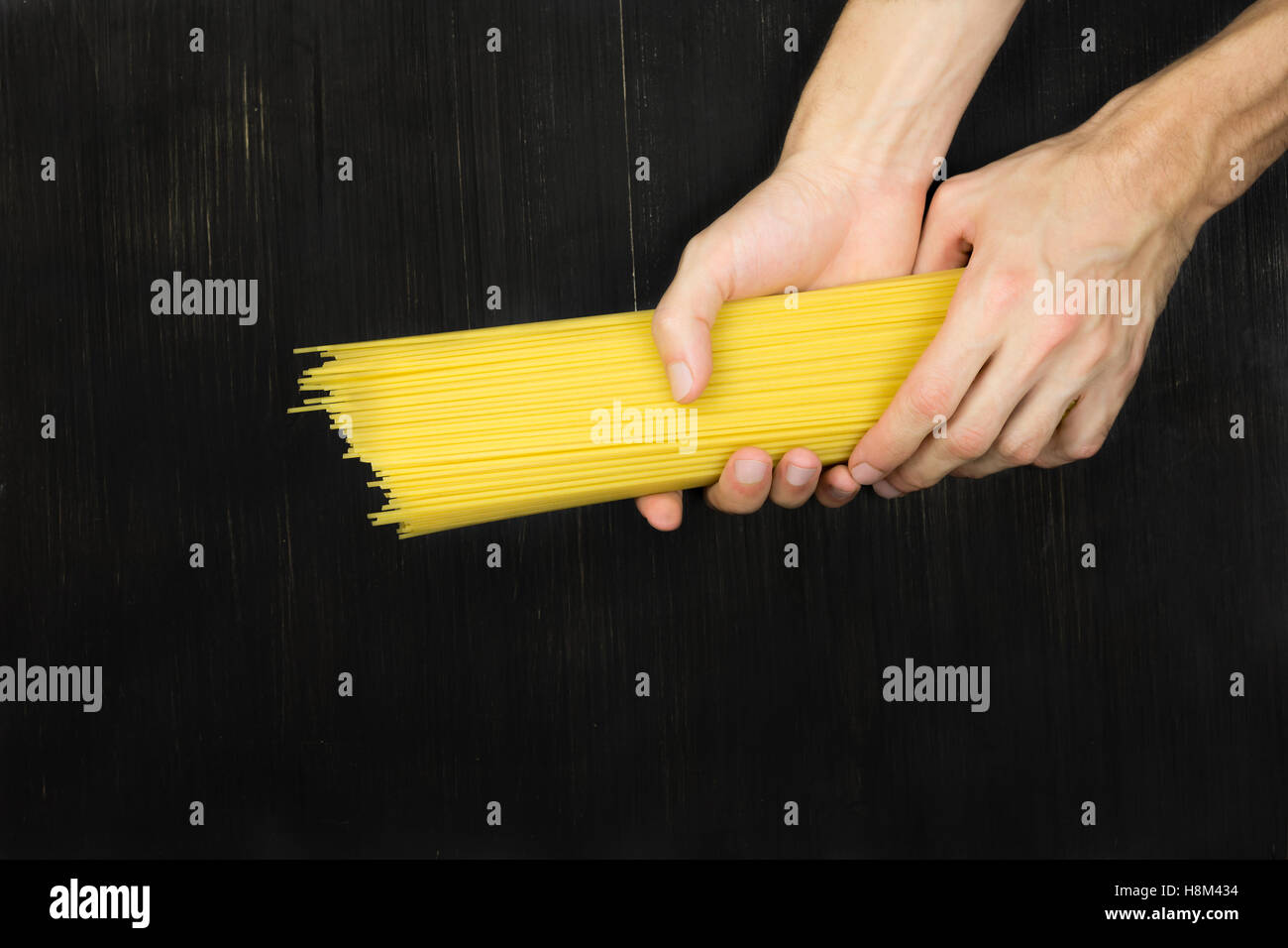 Spaghetti in hands flat lay. Top view bunch of raw spaghetti in male ...