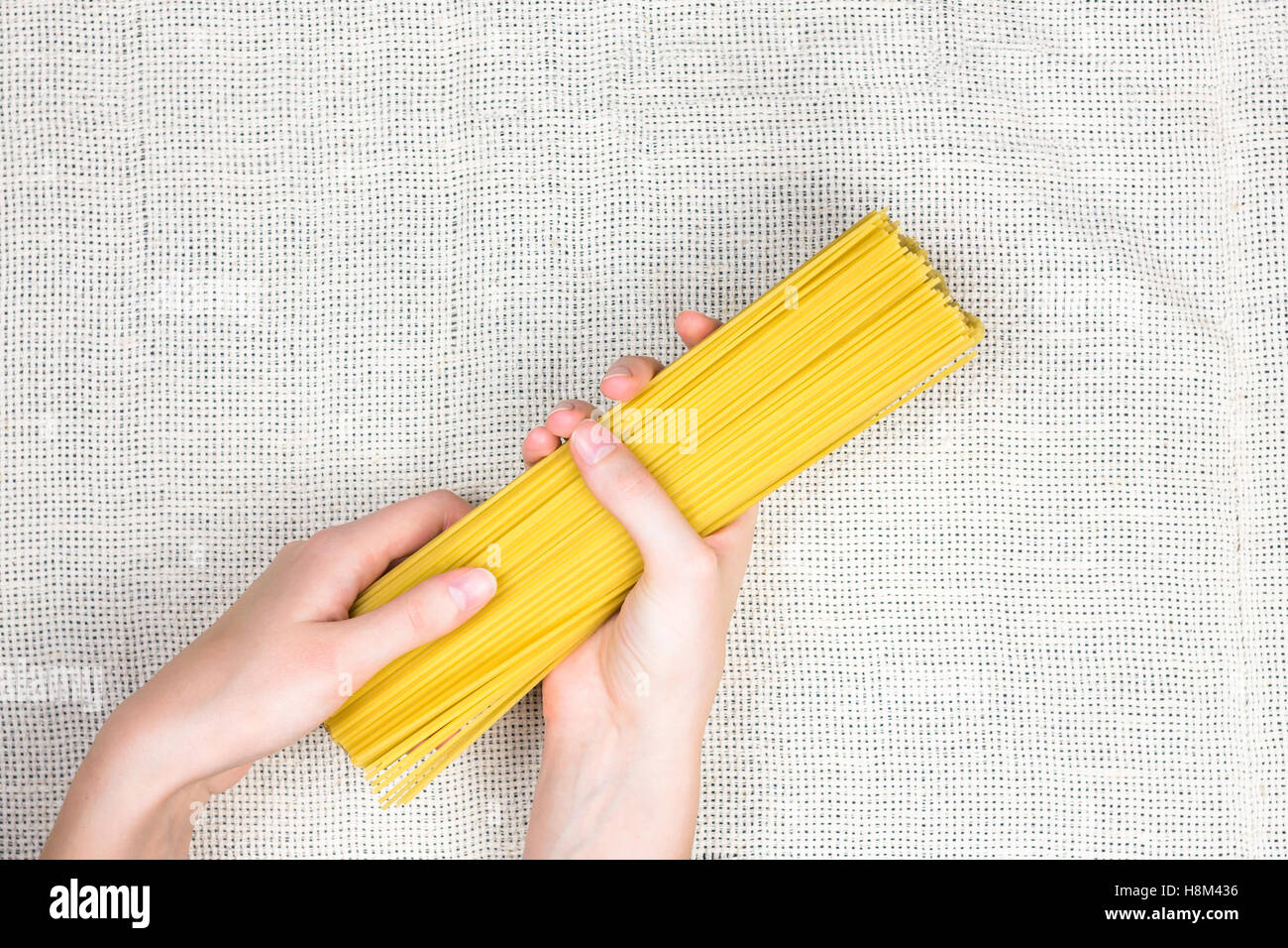 Raw spaghetti in female hands flat lay. Top view of bunch uncooked ...