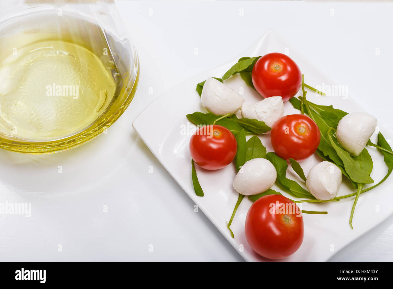 Vegetarian raw food plate with tomato, ruccola and mozzarella next to a ...