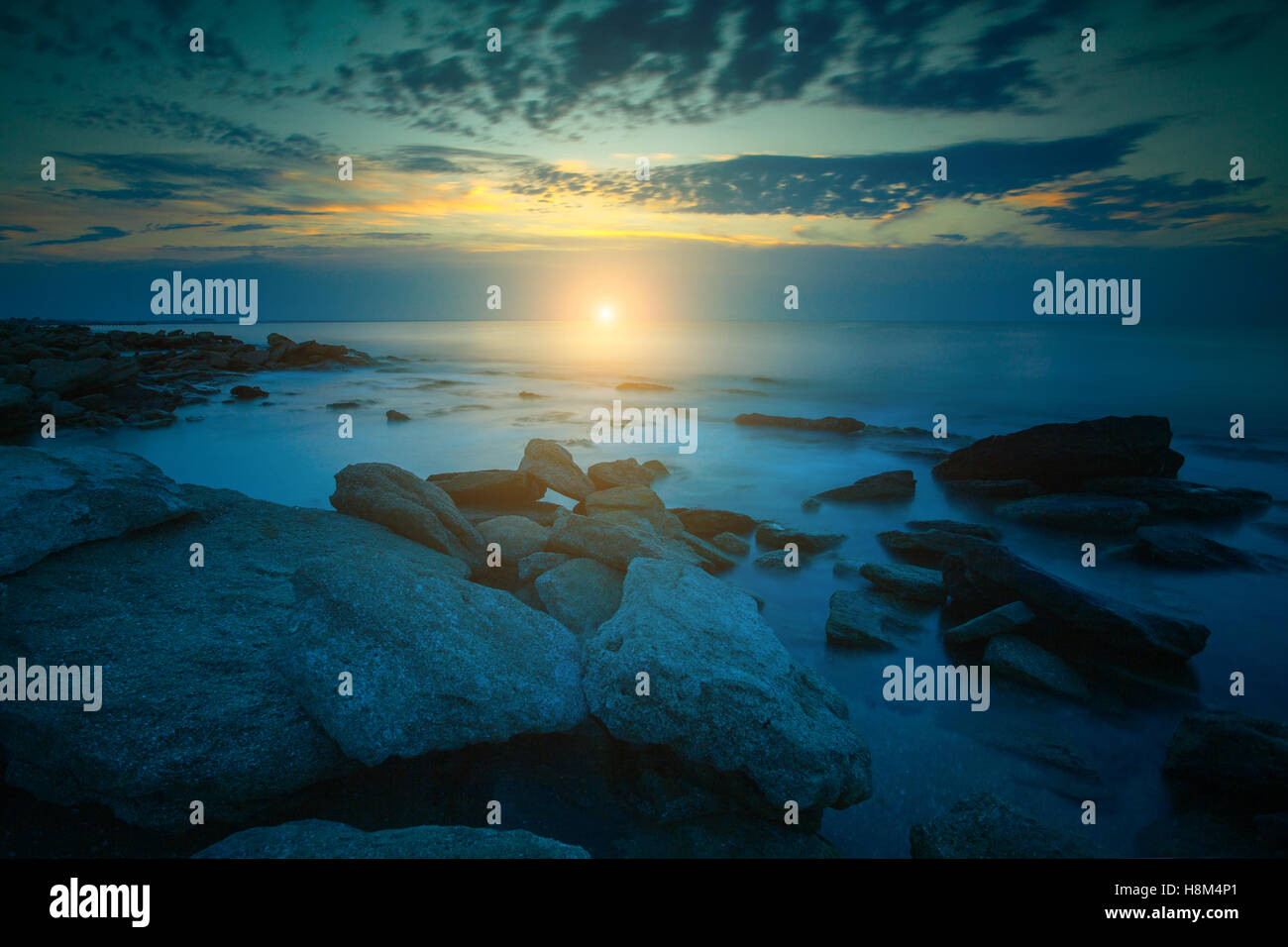 Early morning, sunrise over rocky sea shore Stock Photo - Alamy