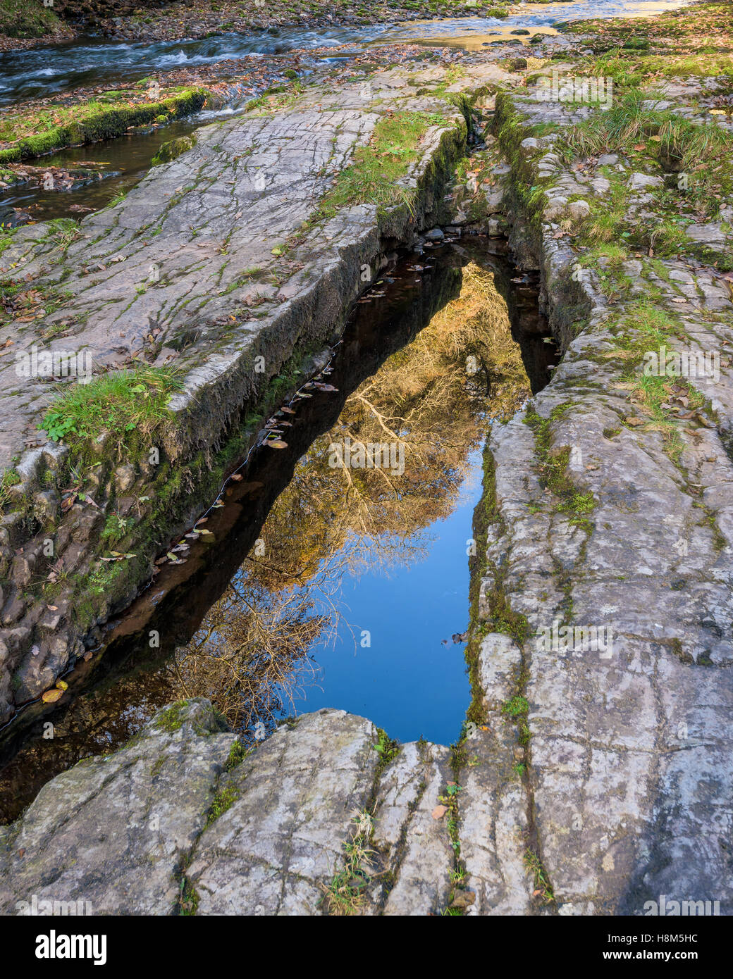 Reflection in a river bed rock pool on the Nedd Fechan river, Wales, UK ...