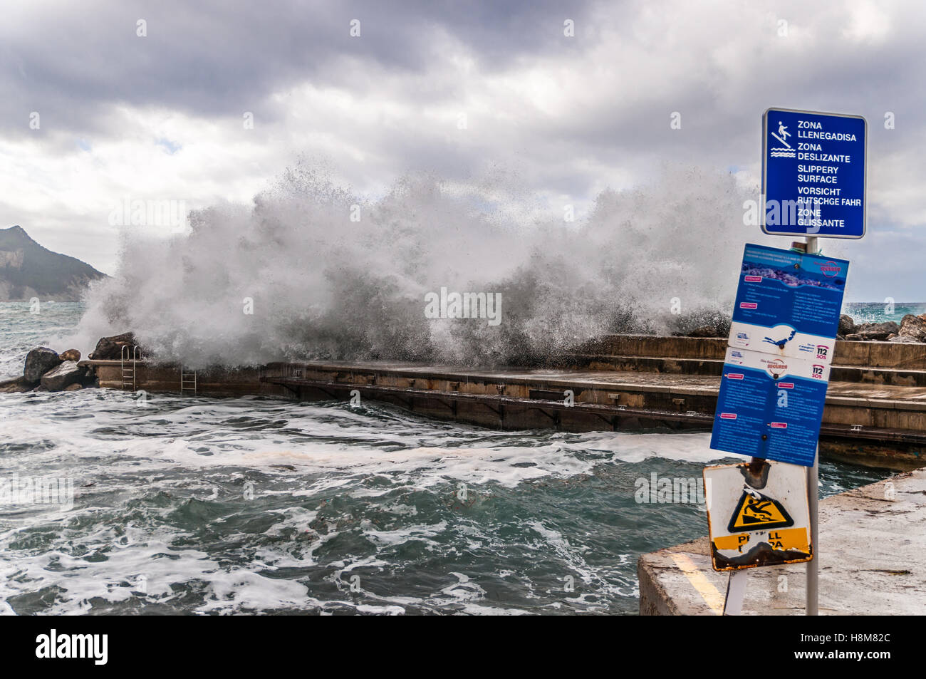 Surf with protective wall and warning signs on Majorca Stock Photo - Alamy