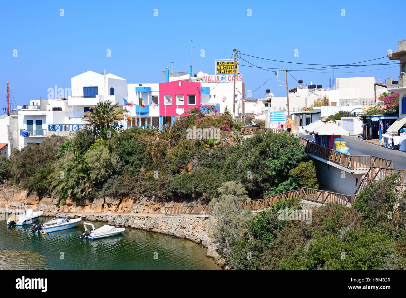 Small boats moored in a small bay off the harbour with town buildings ...