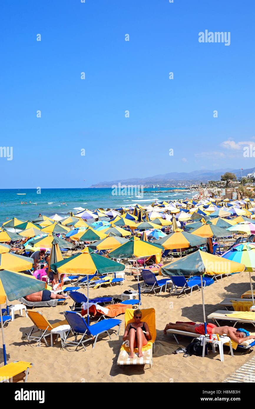 Tourists relaxing on the beach with views towards the sea, Stalida ...