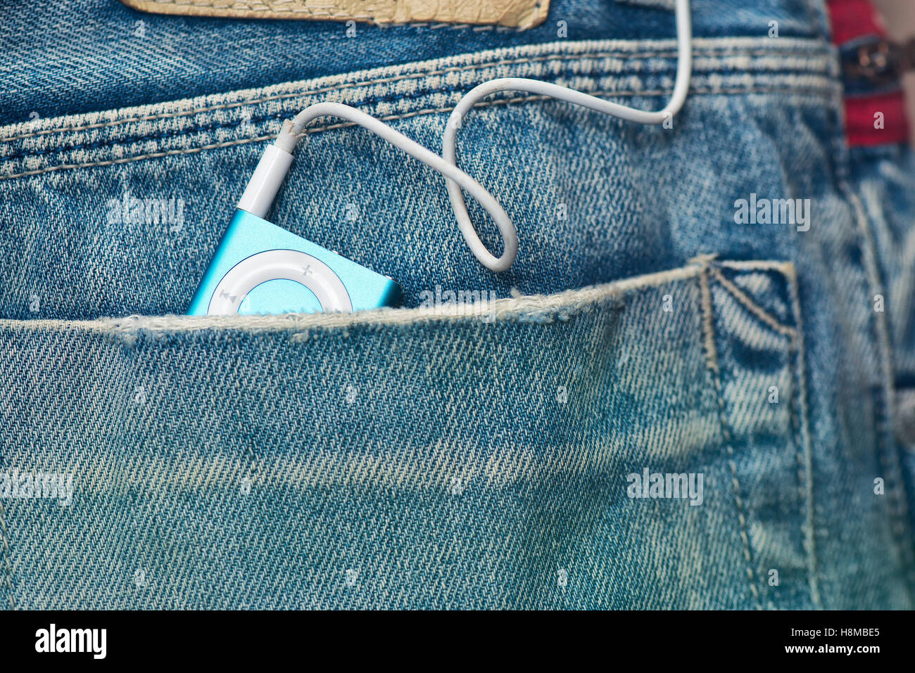 MP3 player in jeans pocket with headphones wire Stock Photo - Alamy