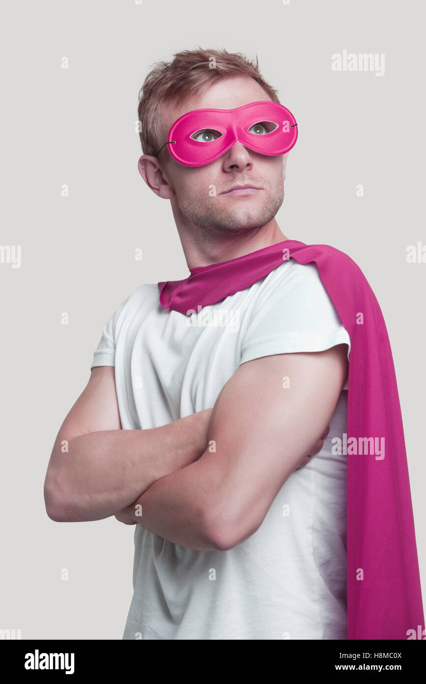 Superhero wearing pink cape and mask Stock Photo - Alamy