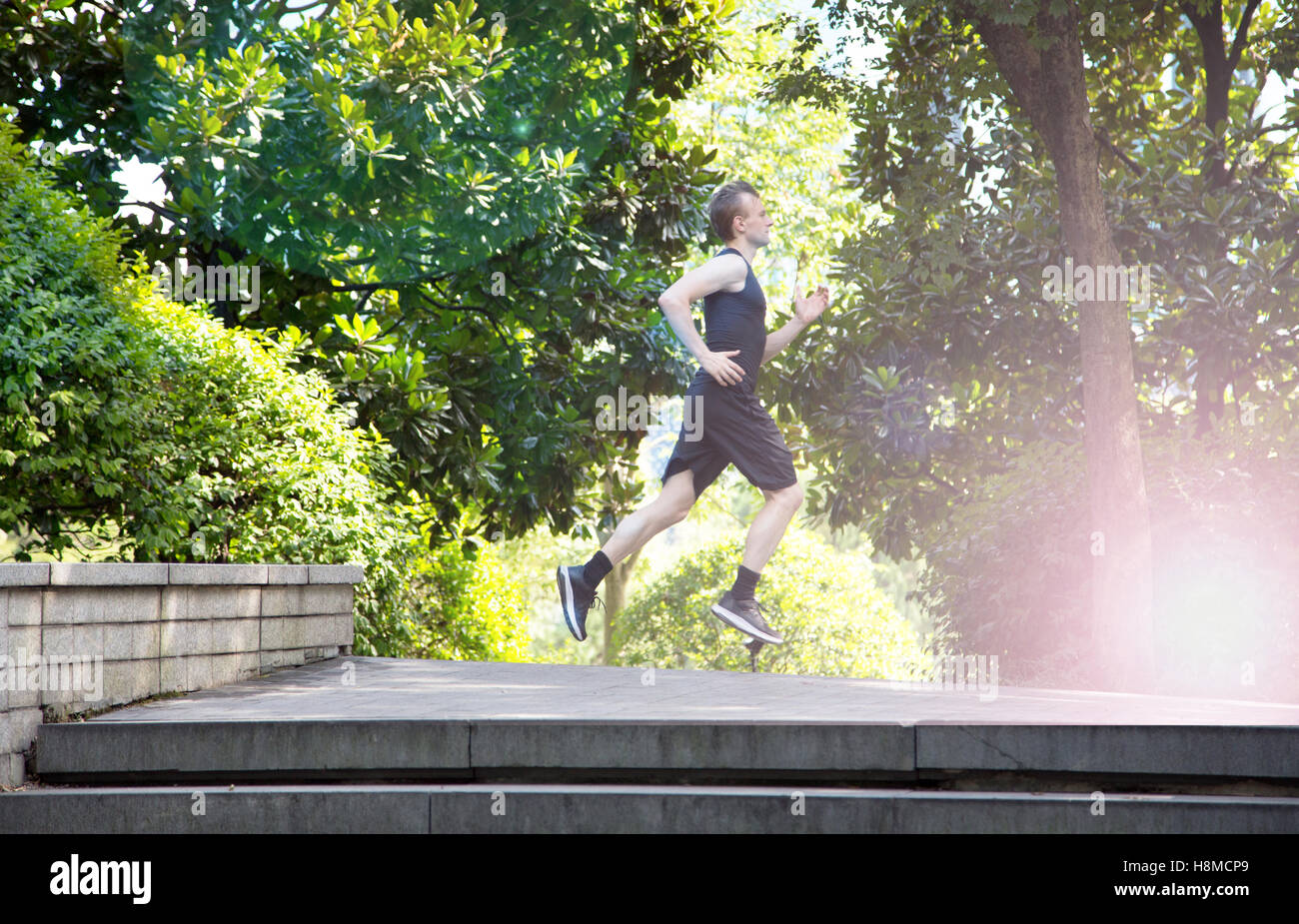 Side view of man running in park Stock Photo - Alamy