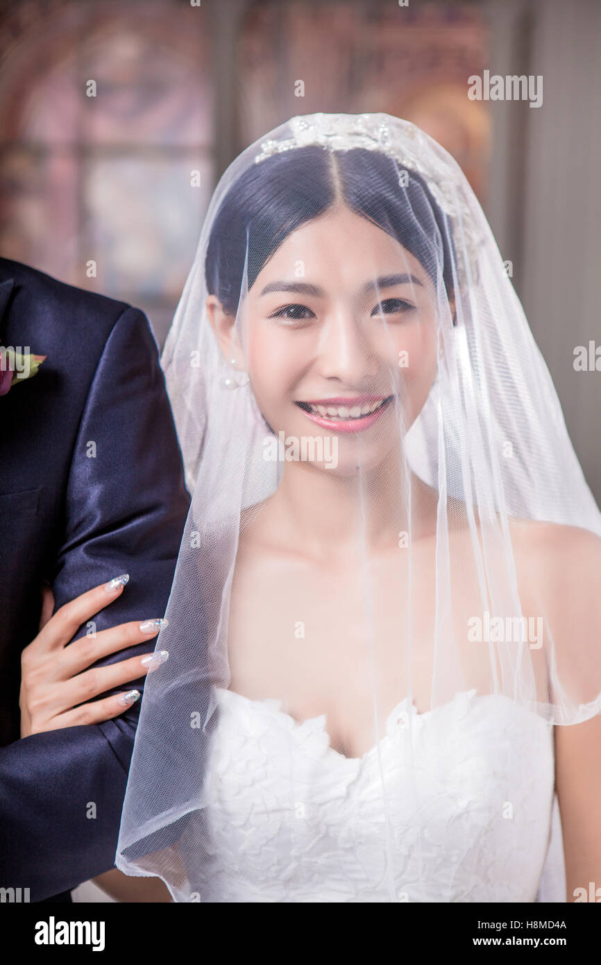 Portrait of happy bride standing with bridegroom in church Stock Photo ...