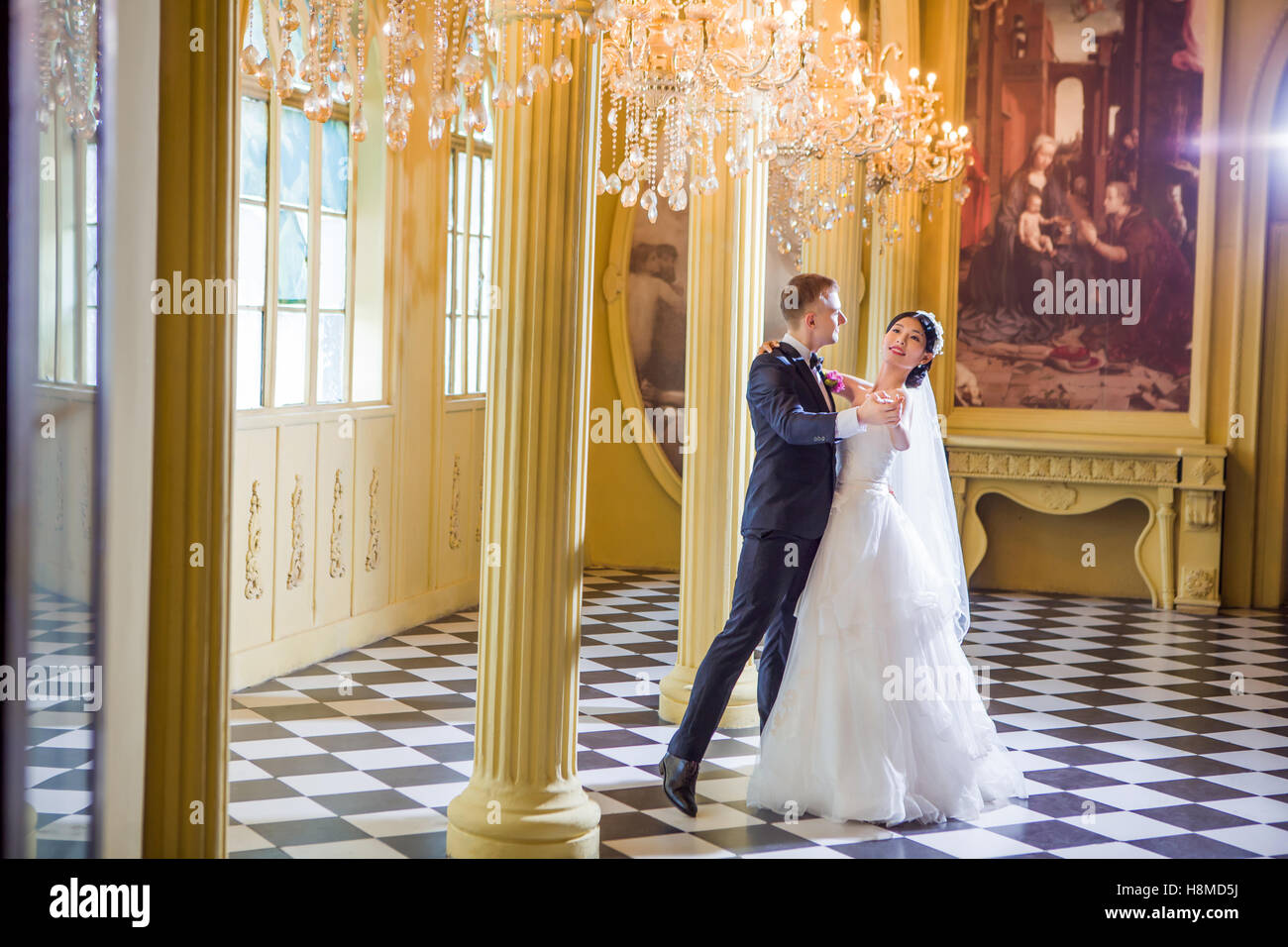 Full length of wedding couple dancing in church Stock Photo - Alamy