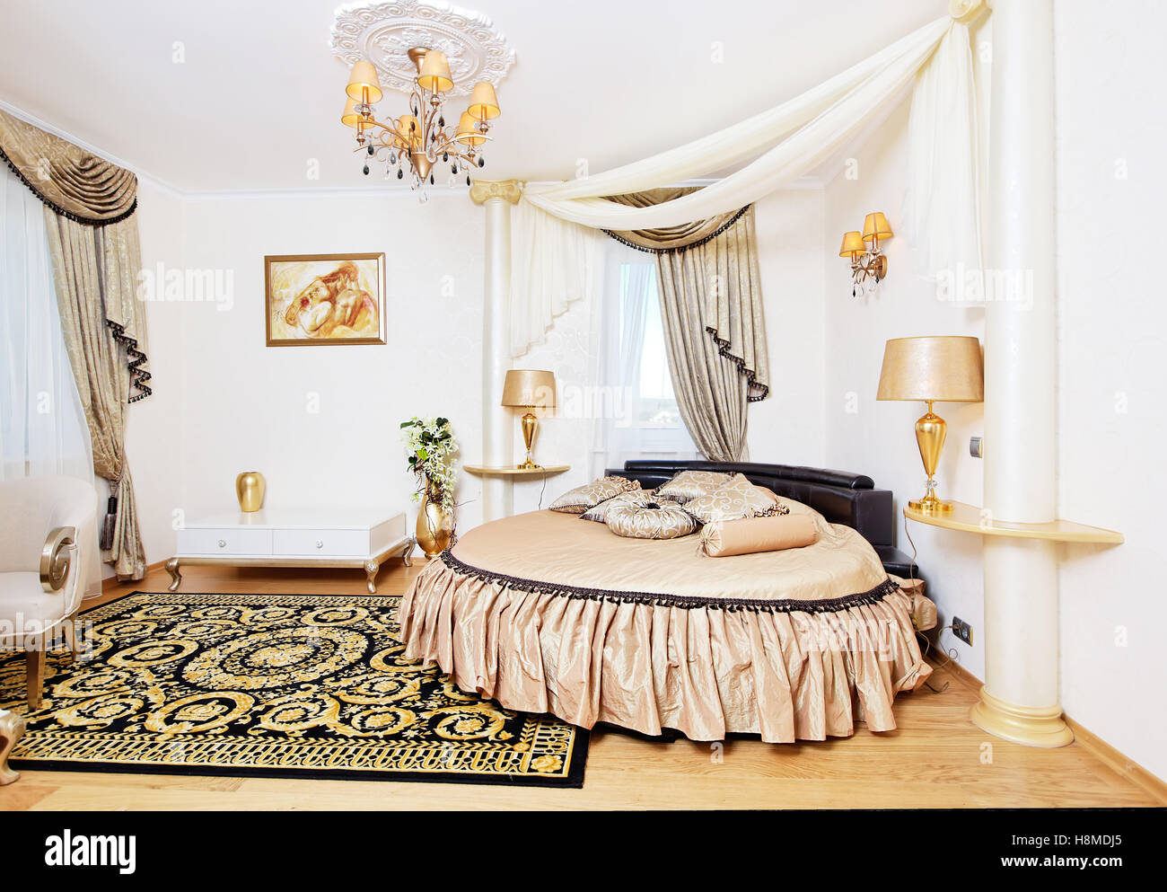 Golden classical bedroom interior with round bed and small table ...
