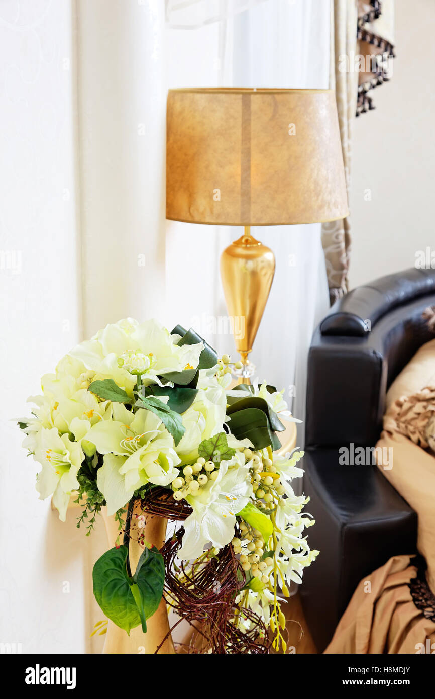 Golden vase with flowers near beautiful golden table lamp Stock Photo ...