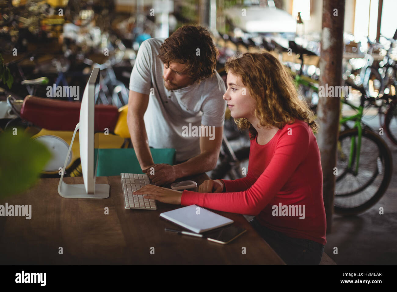 Couple using computer at table Stock Photo - Alamy