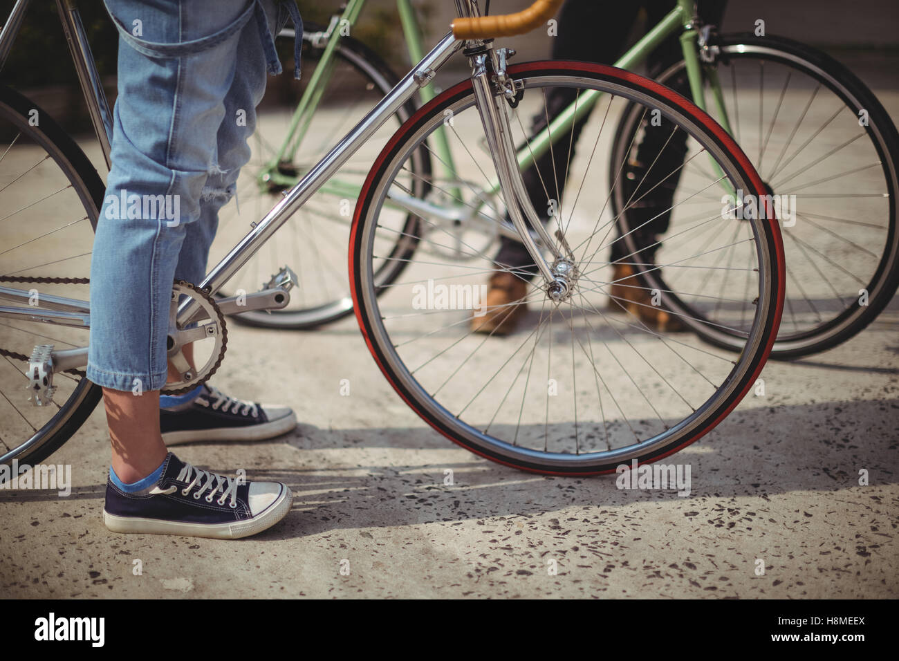 Woman standing with bicycle Stock Photo - Alamy
