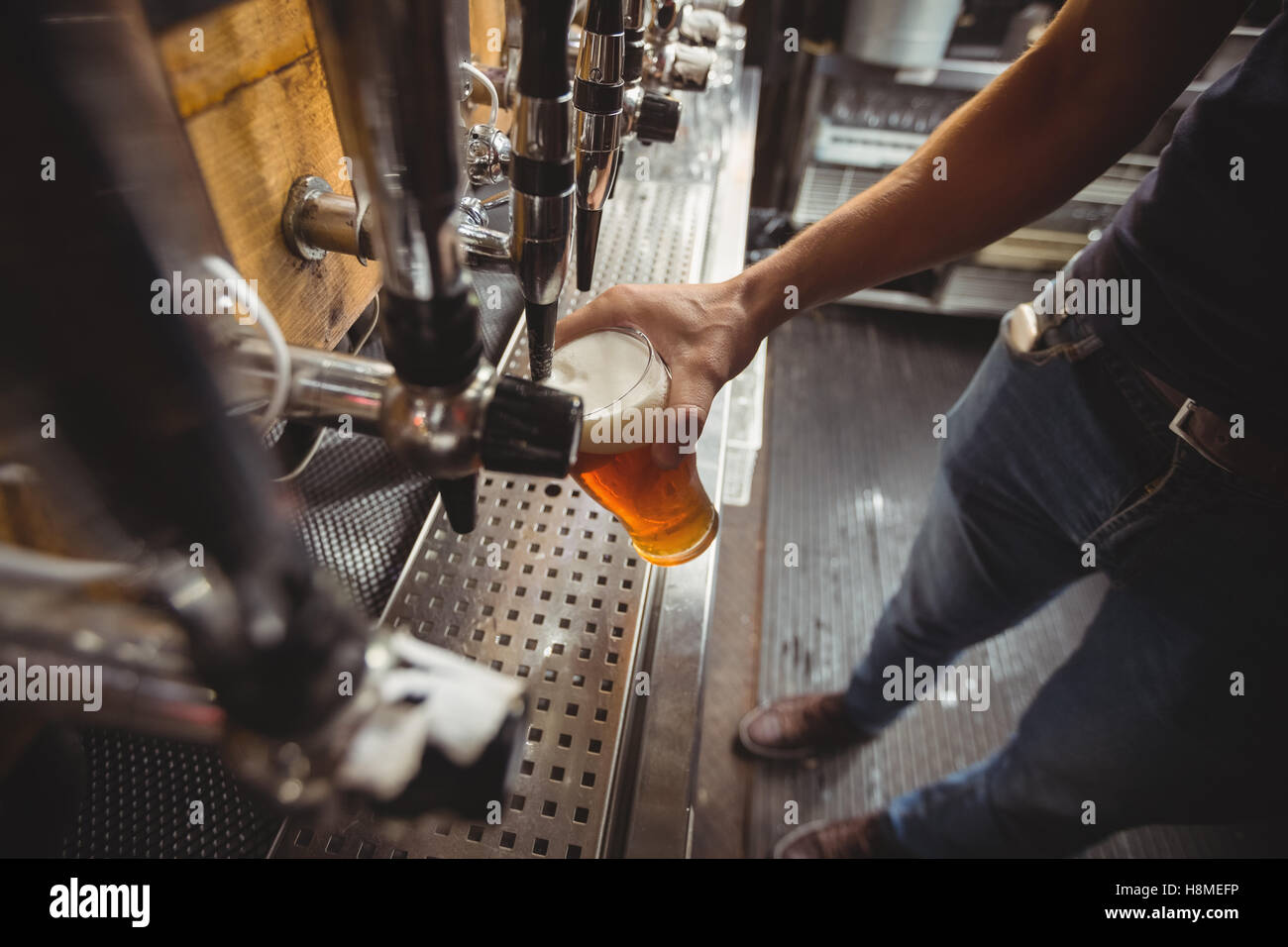 Close-up of bar tender filling beer from bar pump Stock Photo - Alamy