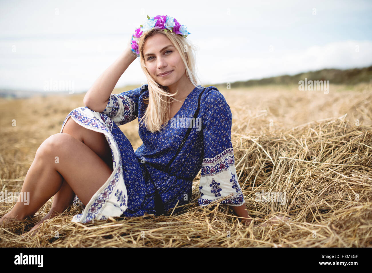 Blonde woman sitting in field Stock Photo - Alamy