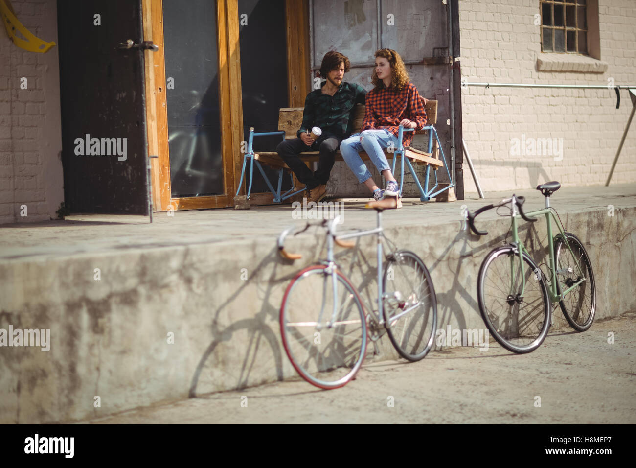 Couple sitting on chair and interacting Stock Photo - Alamy