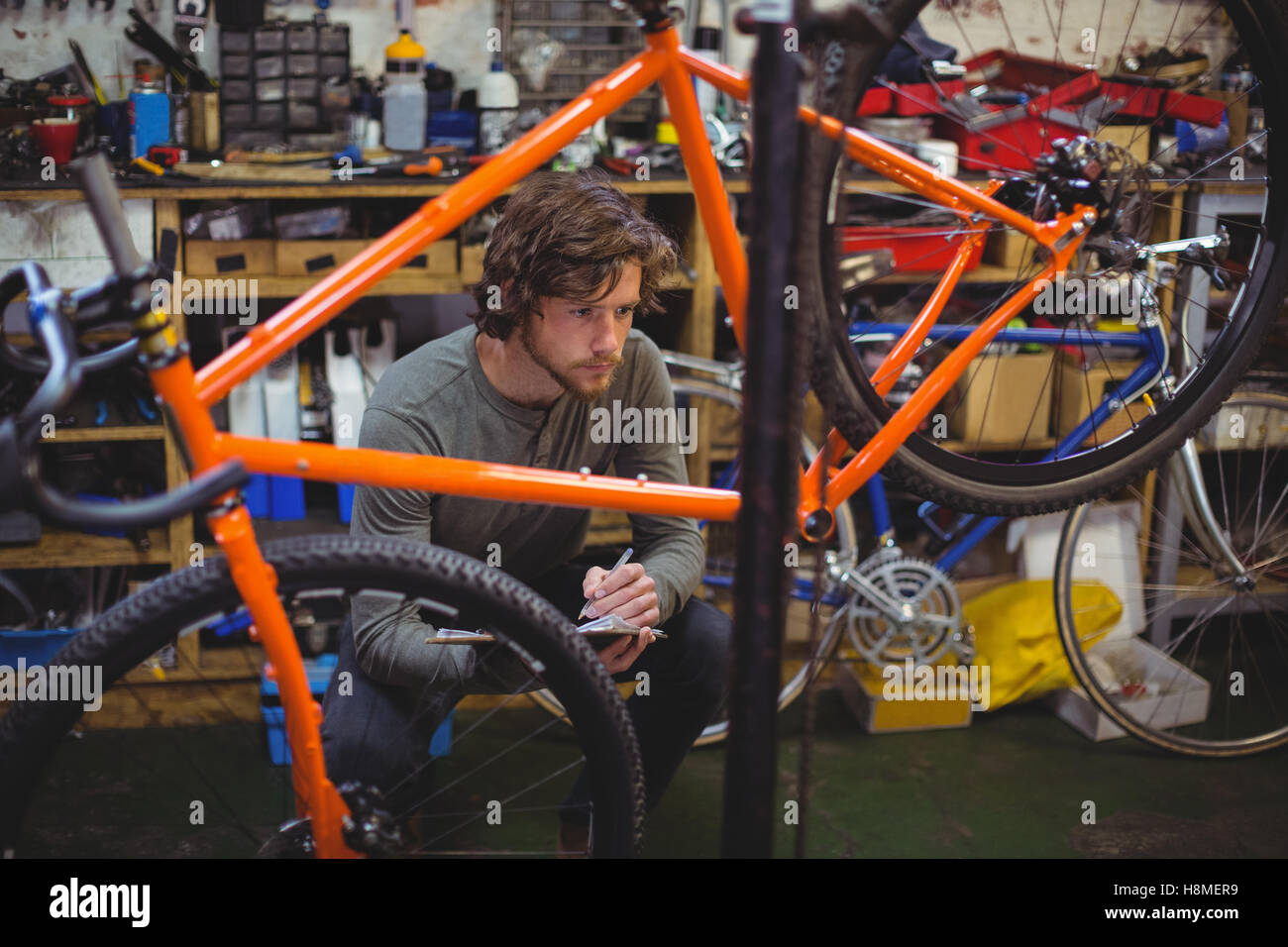 Mechanic writing on clipboard Stock Photo - Alamy