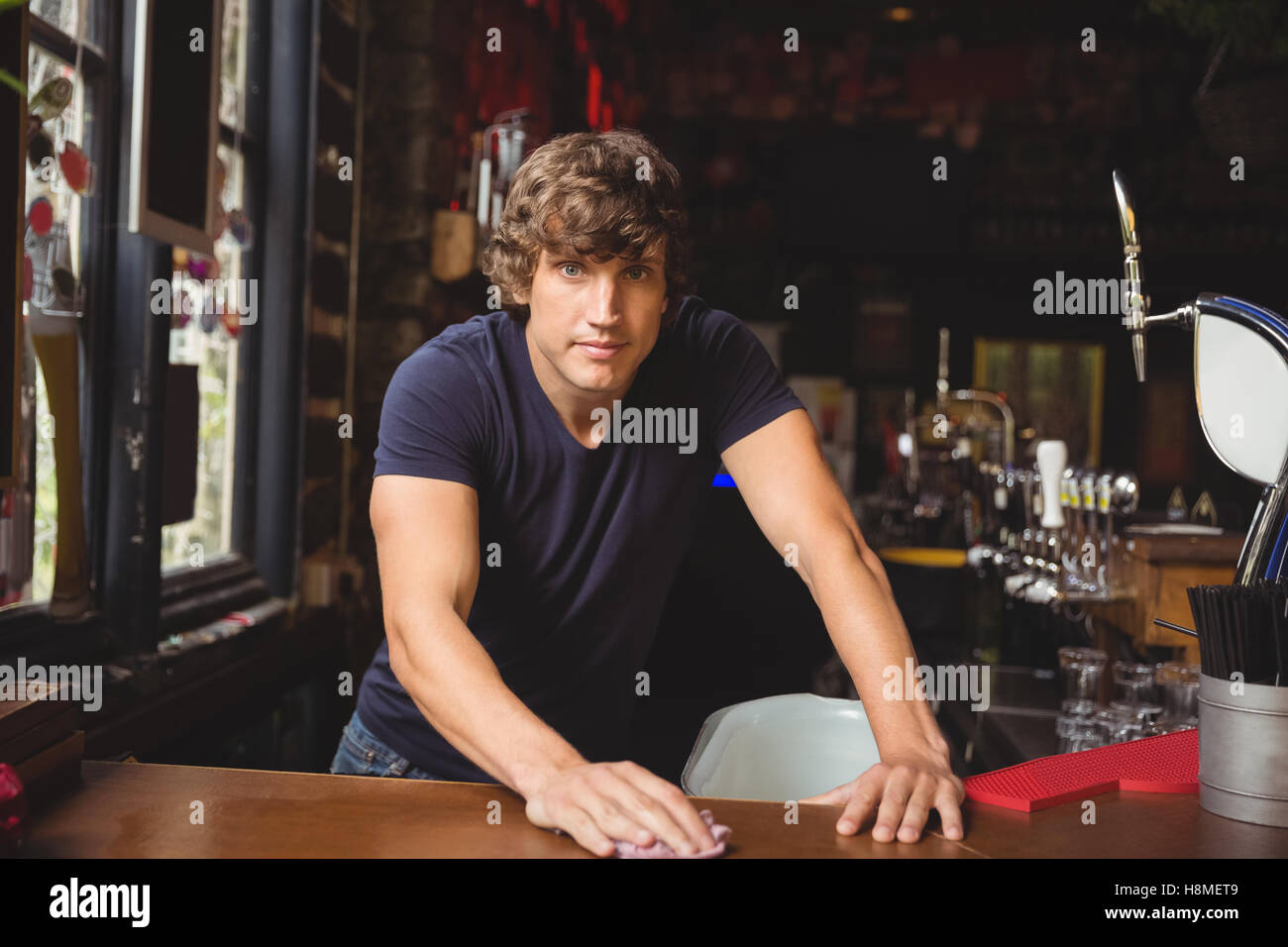 Portrait of bar tender cleaning bar counter Stock Photo - Alamy