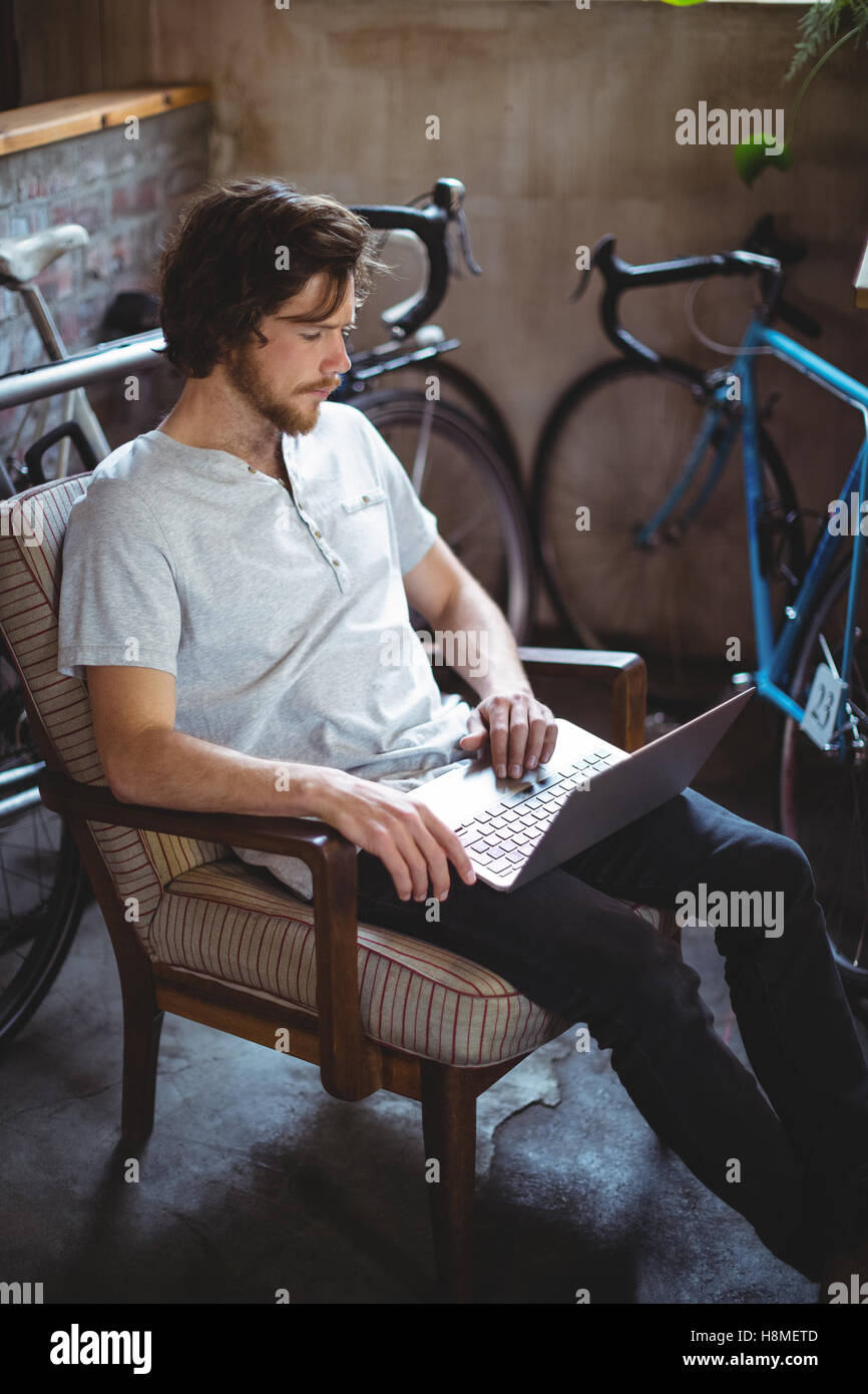 Man sitting on chair and using laptop Stock Photo - Alamy