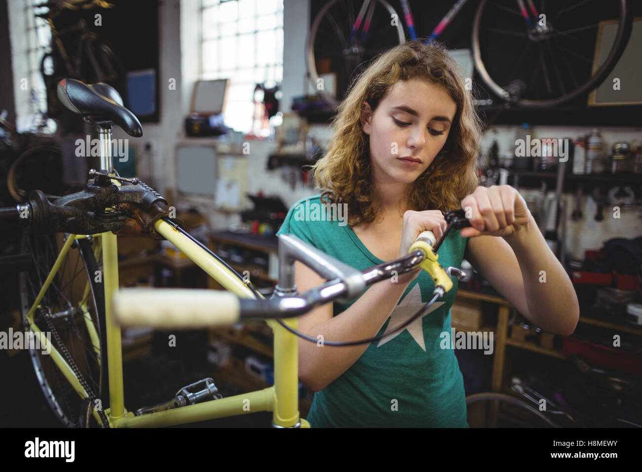 Mechanic examining bicycle Stock Photo - Alamy