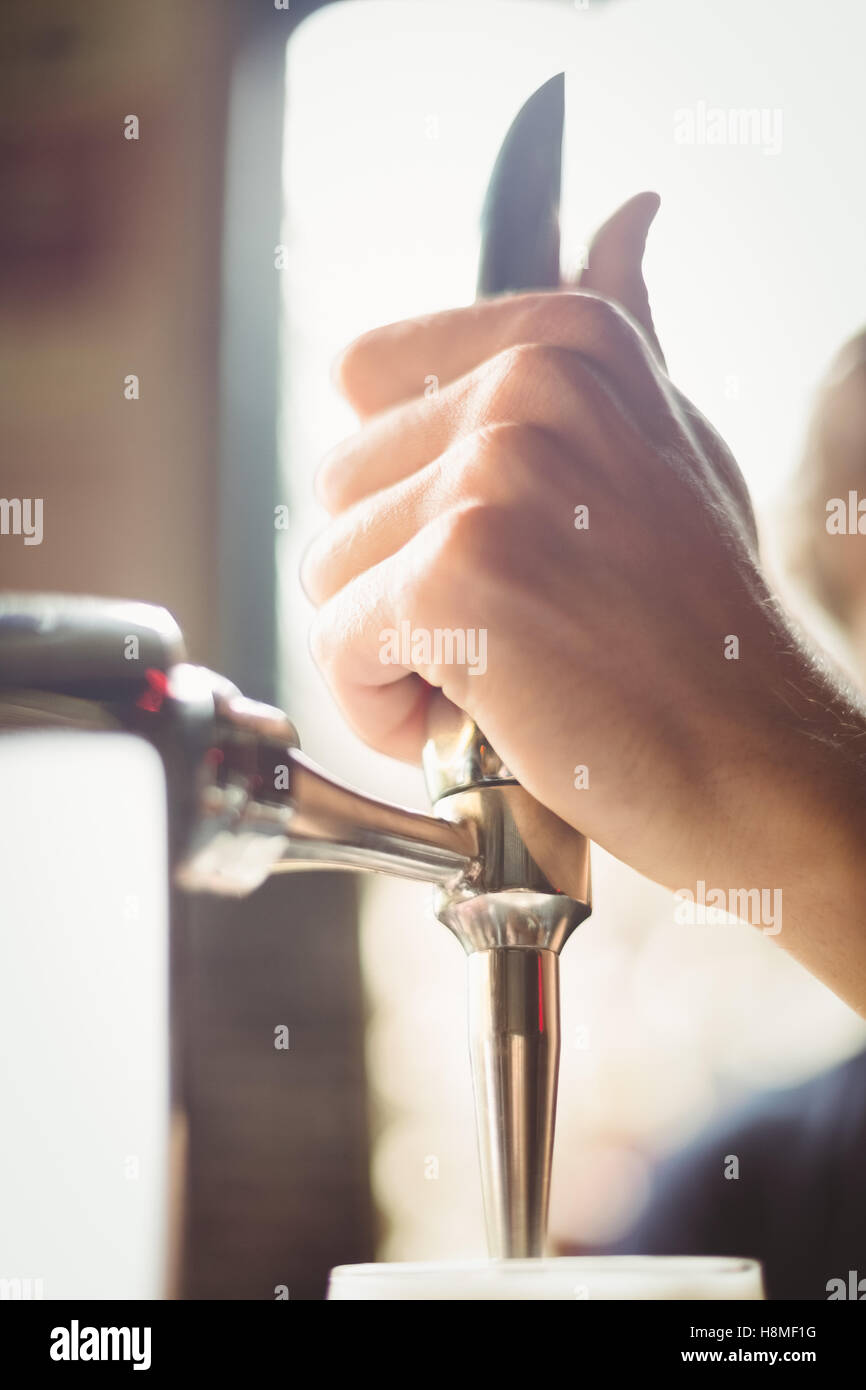 Close-up of bar tender filling beer from bar pump Stock Photo - Alamy