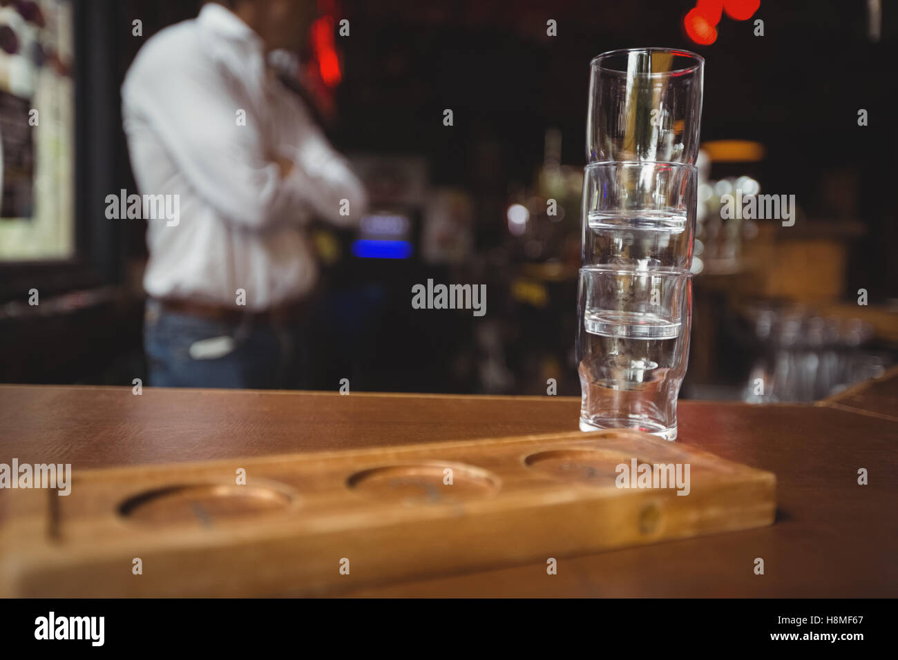 Empty stack of beer glass and tray at bar counter Stock Photo - Alamy