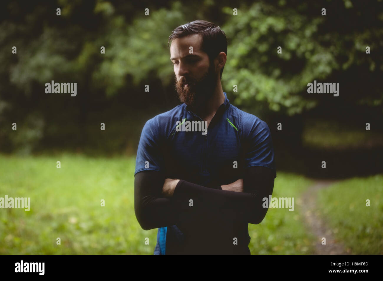 Athlete standing with arms crossed Stock Photo - Alamy