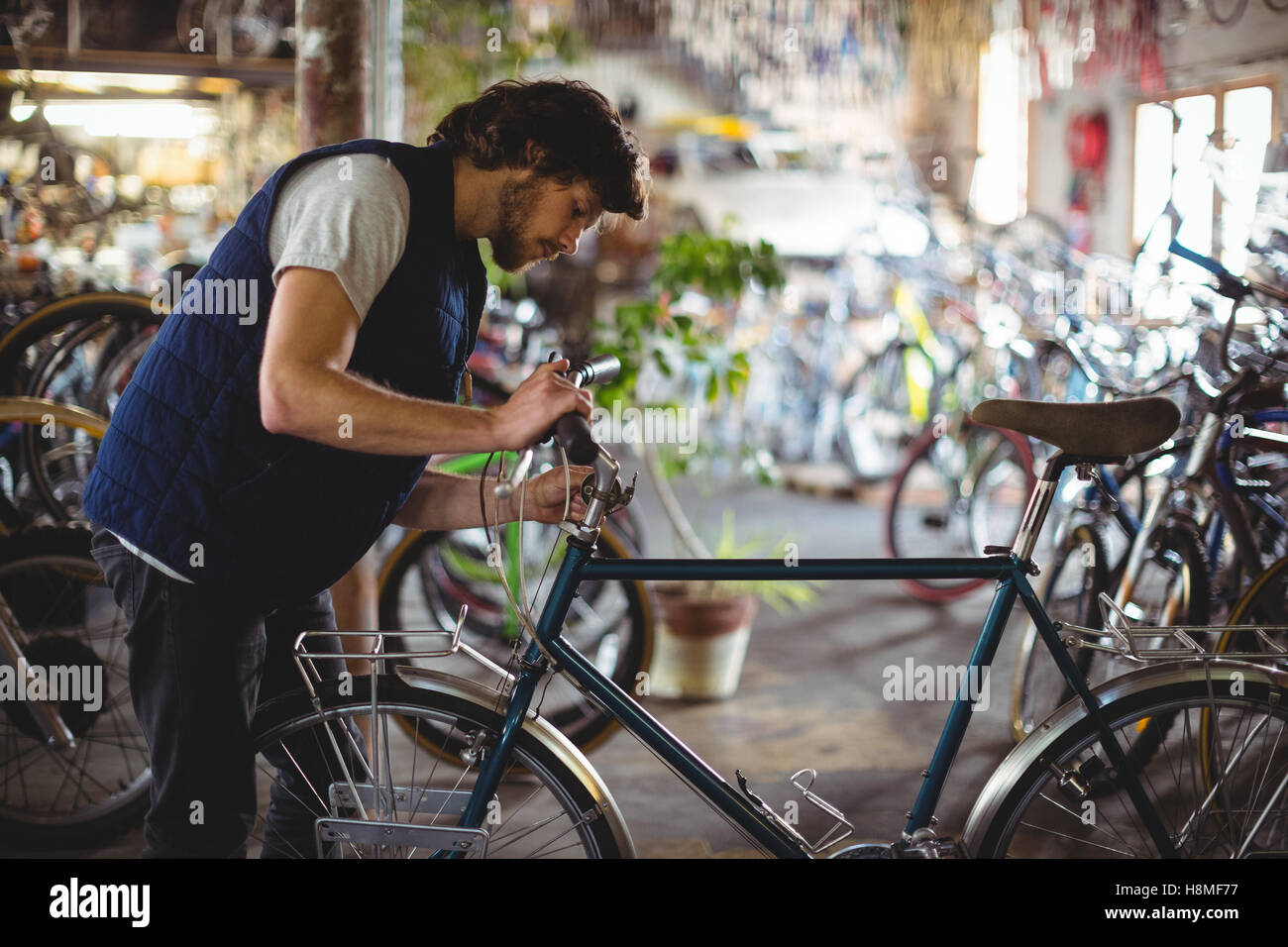 Mechanic examining bicycle Stock Photo - Alamy