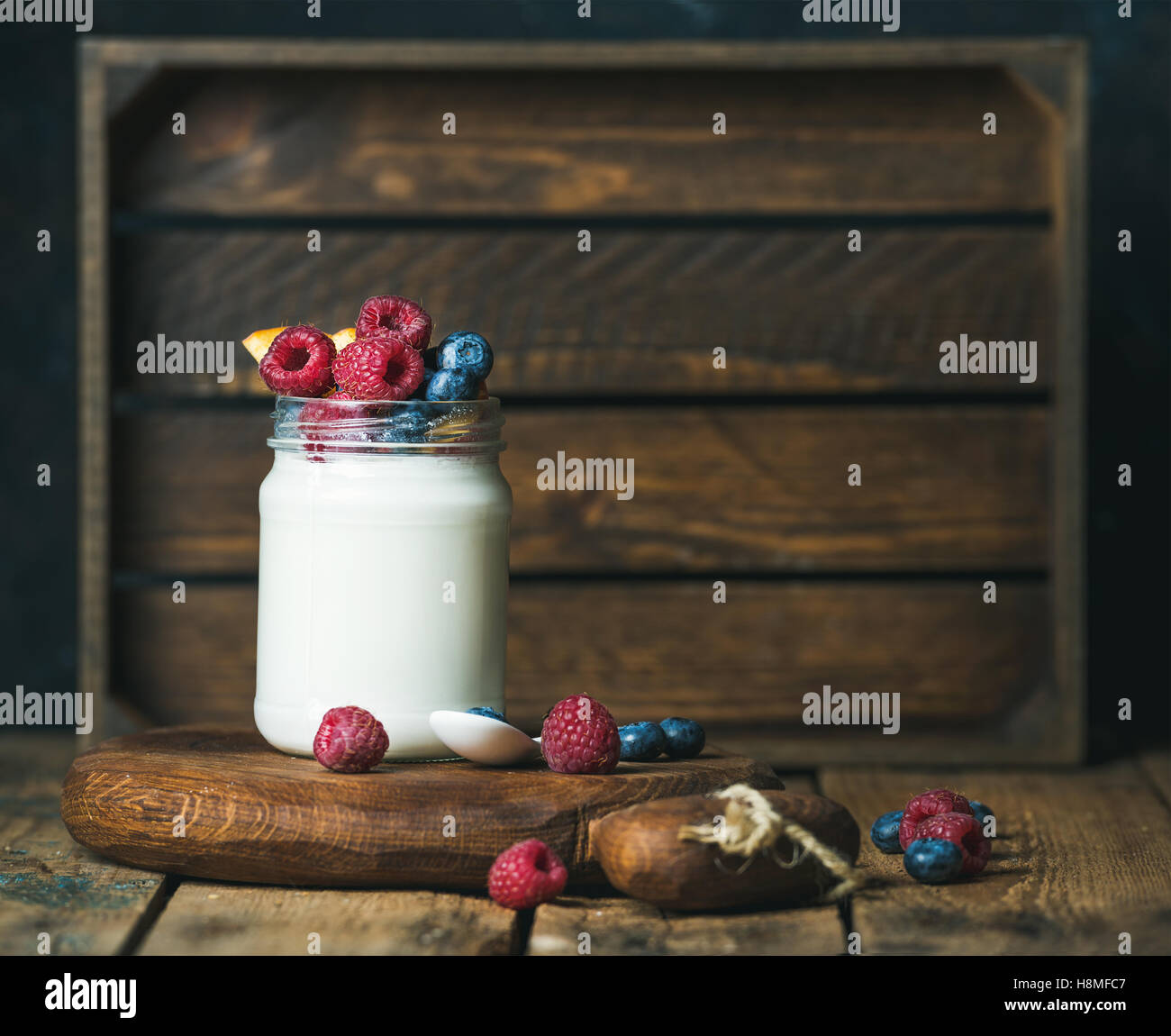Glass jar of yogurt with berries and peach on board Stock Photo - Alamy