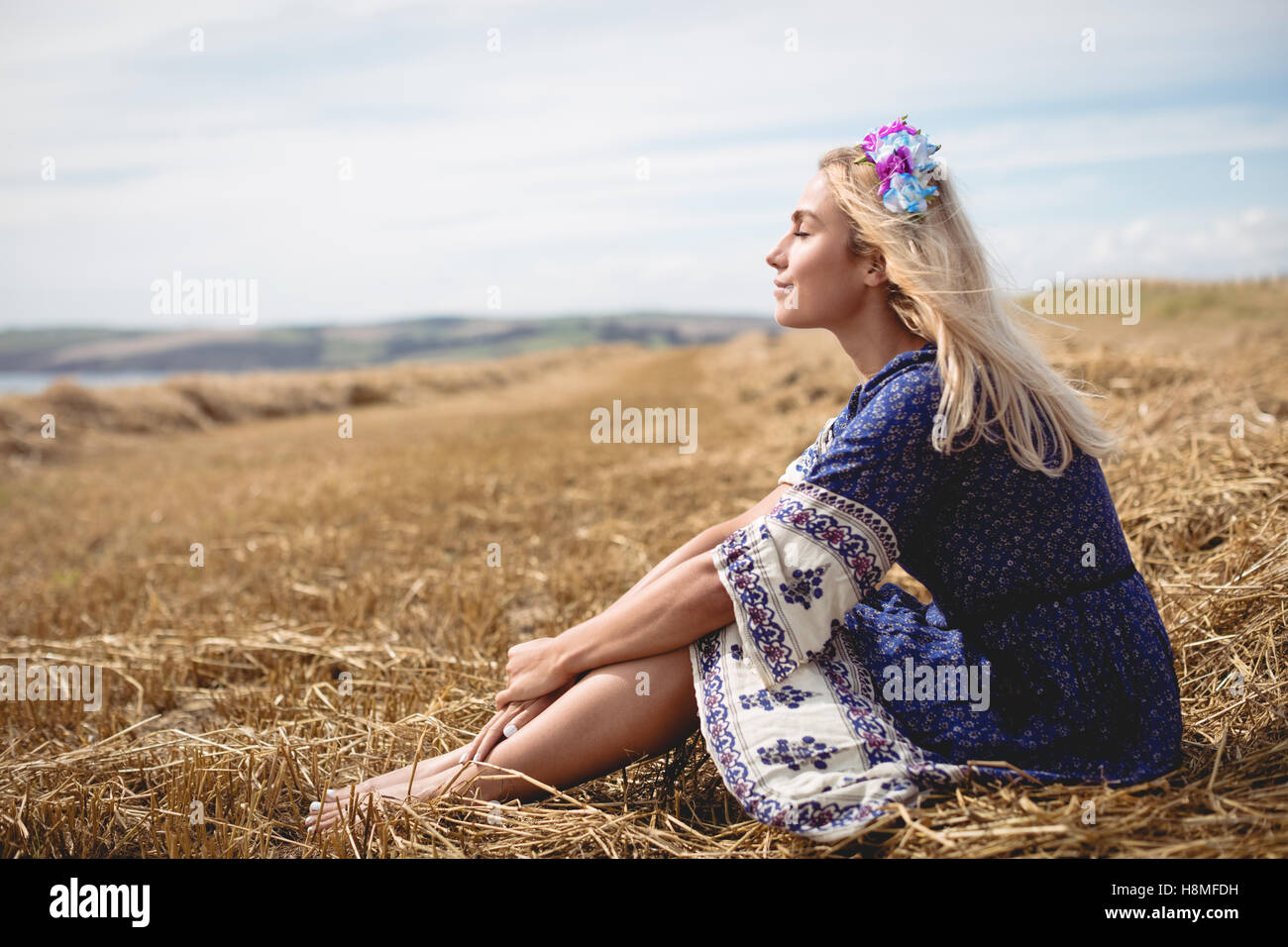 Blonde woman relaxing in field Stock Photo - Alamy