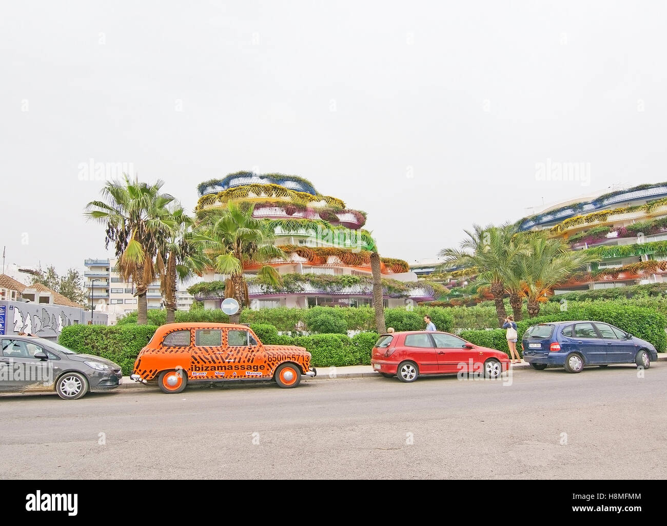 Orange hippie car in front of colorful design building with flower ...