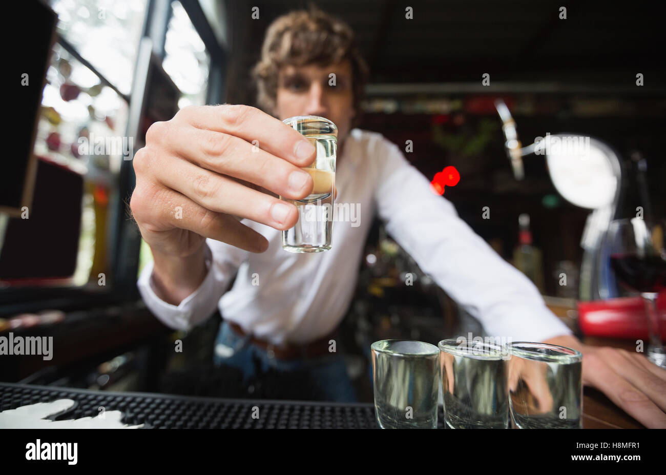 Portrait of bartender holding tequila shot glass at bar counter Stock ...