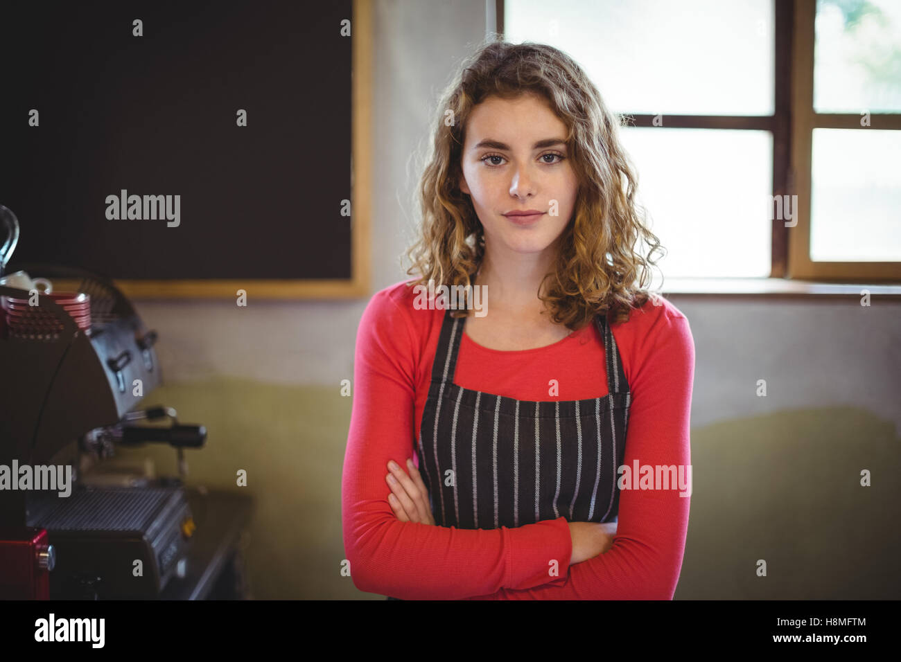 Confident waitress standing with arm crossed in cafÃ© Stock Photo - Alamy
