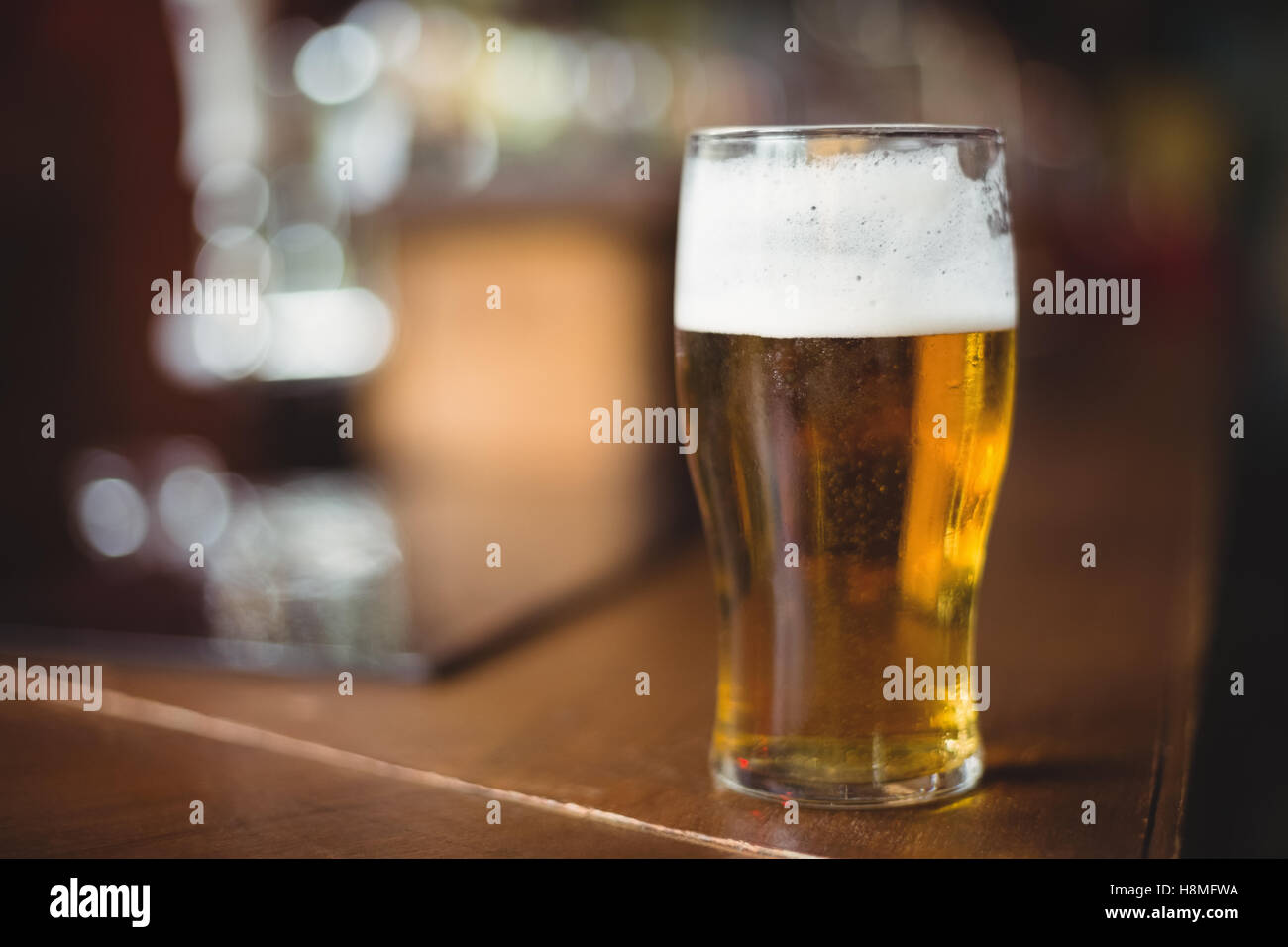 Glass of beer in bar counter Stock Photo - Alamy
