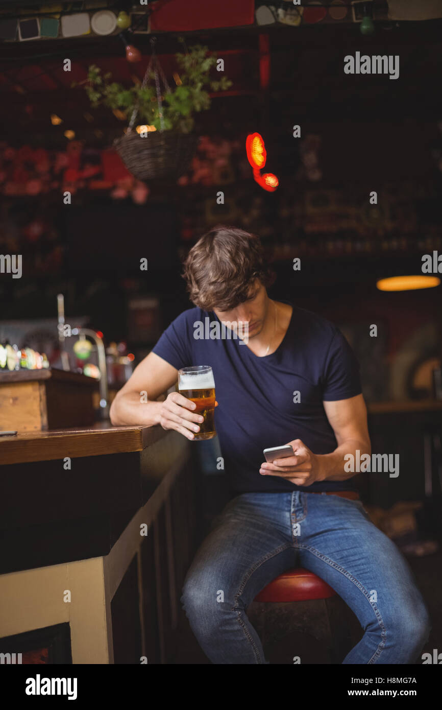 Man using mobile phone while having glass of beer Stock Photo - Alamy