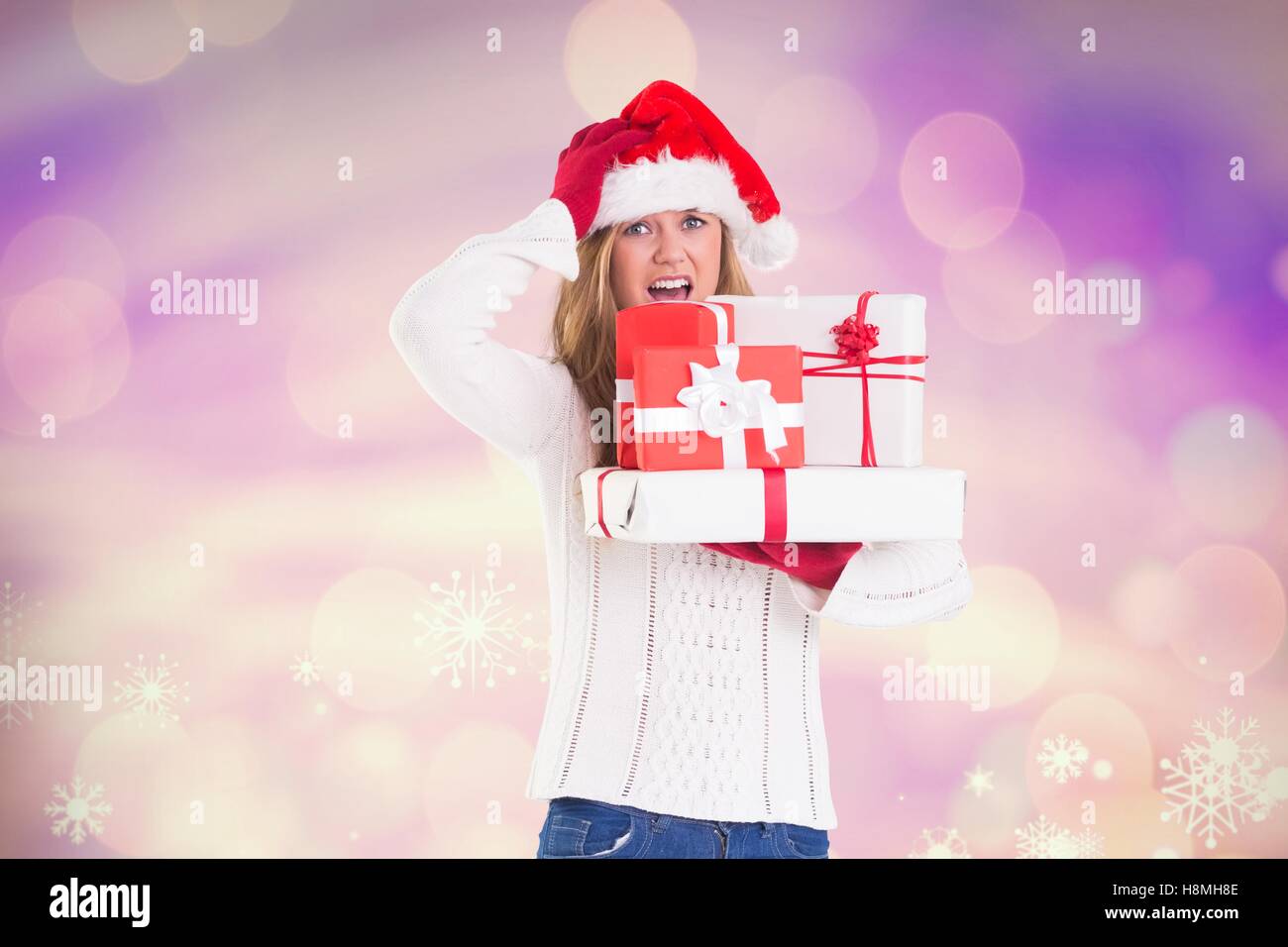 Confused woman in santa hat holding her stack of gifts Stock Photo - Alamy