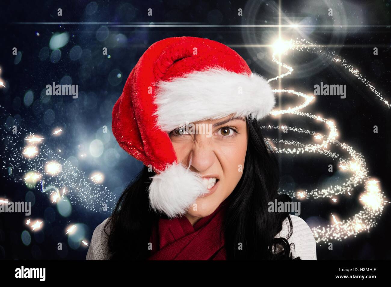Frustrated woman biting santa hat Stock Photo - Alamy