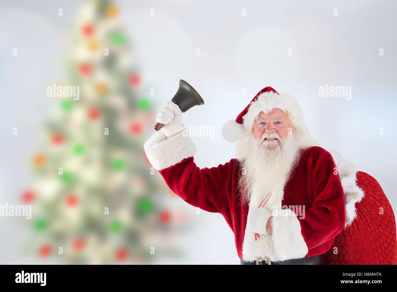 Santa claus holding gift sack and ringing bell Stock Photo - Alamy