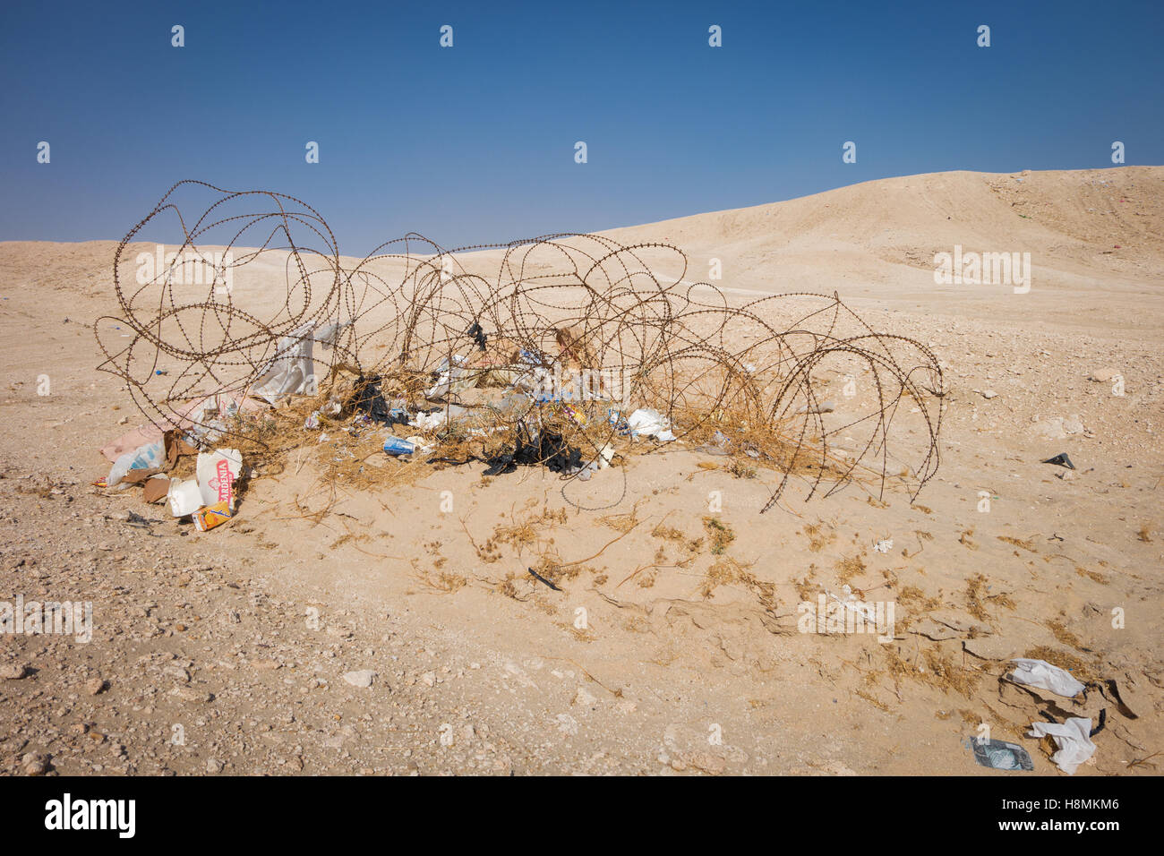 Rusty barbed wire in the desert covered with trash Stock Photo - Alamy