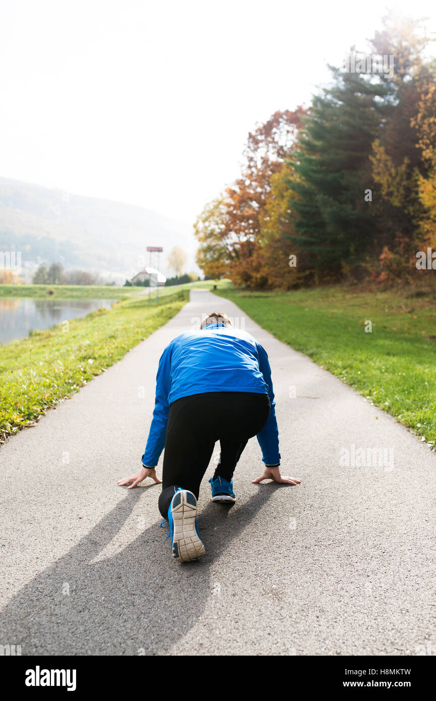 Runner at the lake on asphalt path in steady position Stock Photo - Alamy