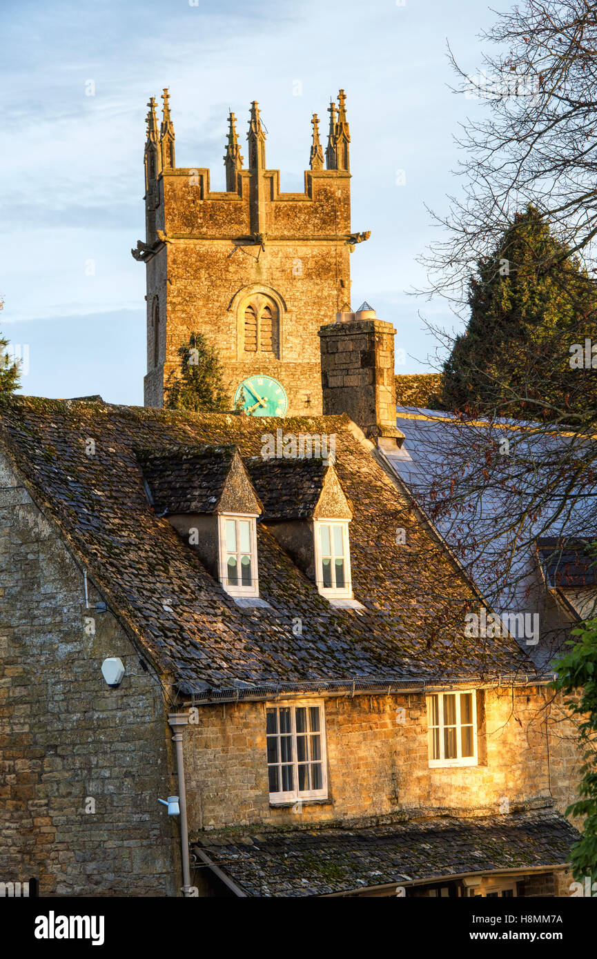 Cottage and St James church in early morning autumn sunlight ...
